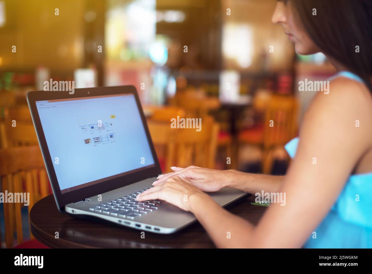 Side view of thin young brunette woman surfing the web on portable ...