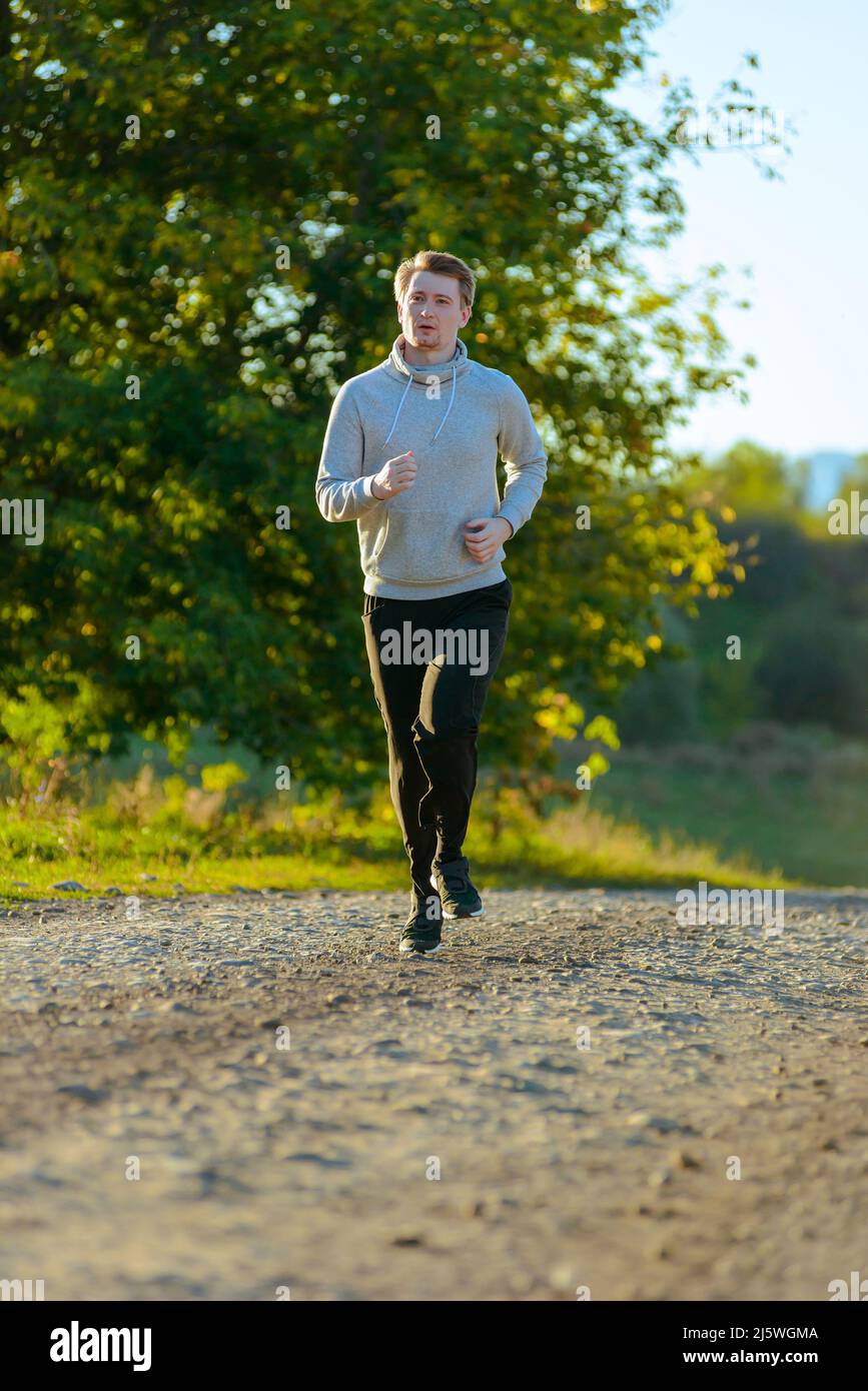 Running man jogging in rural nature at beautiful summer day. Sport ...