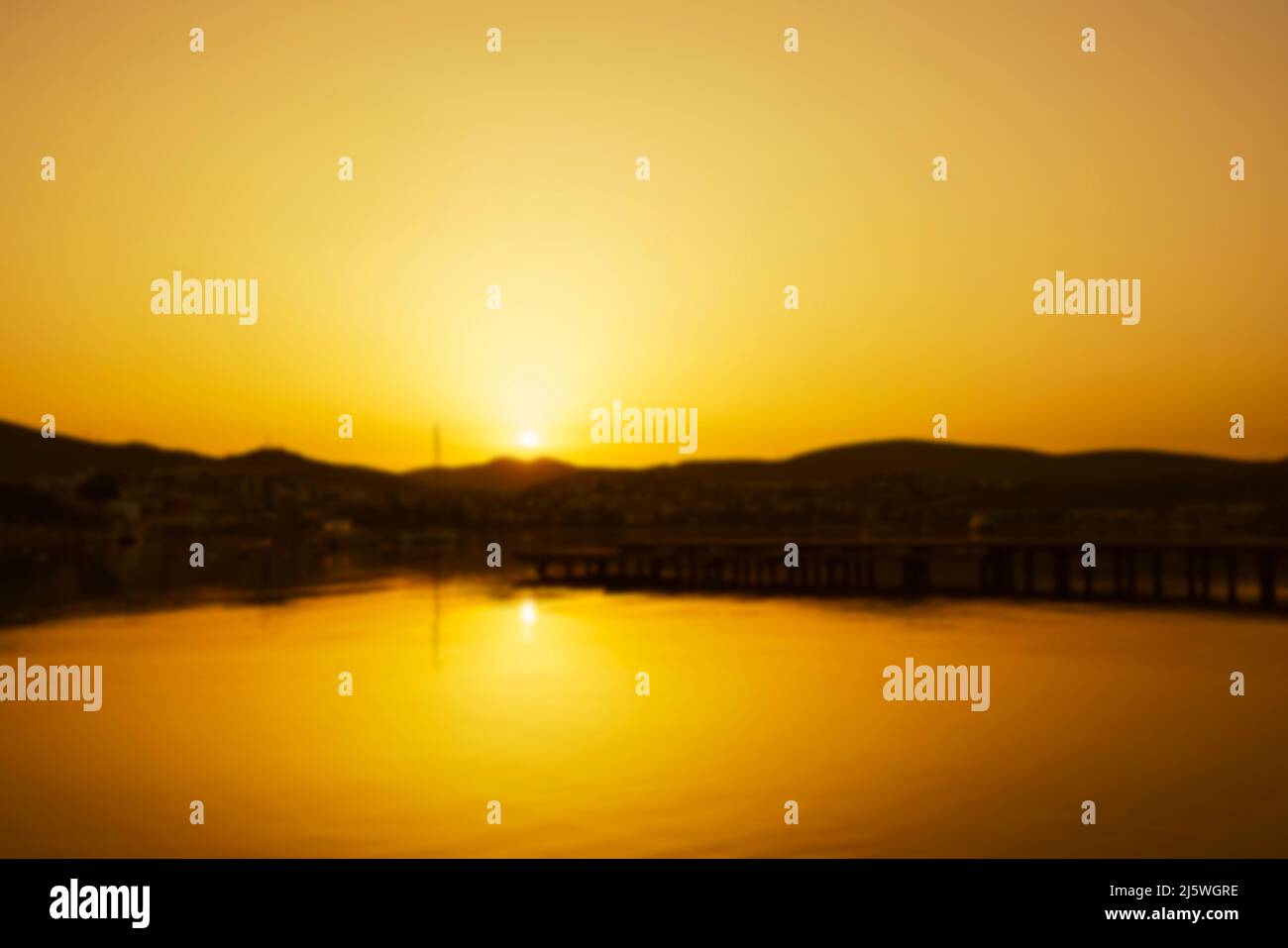 Natural background blurring warm colors and bright sun light, sunset or ...