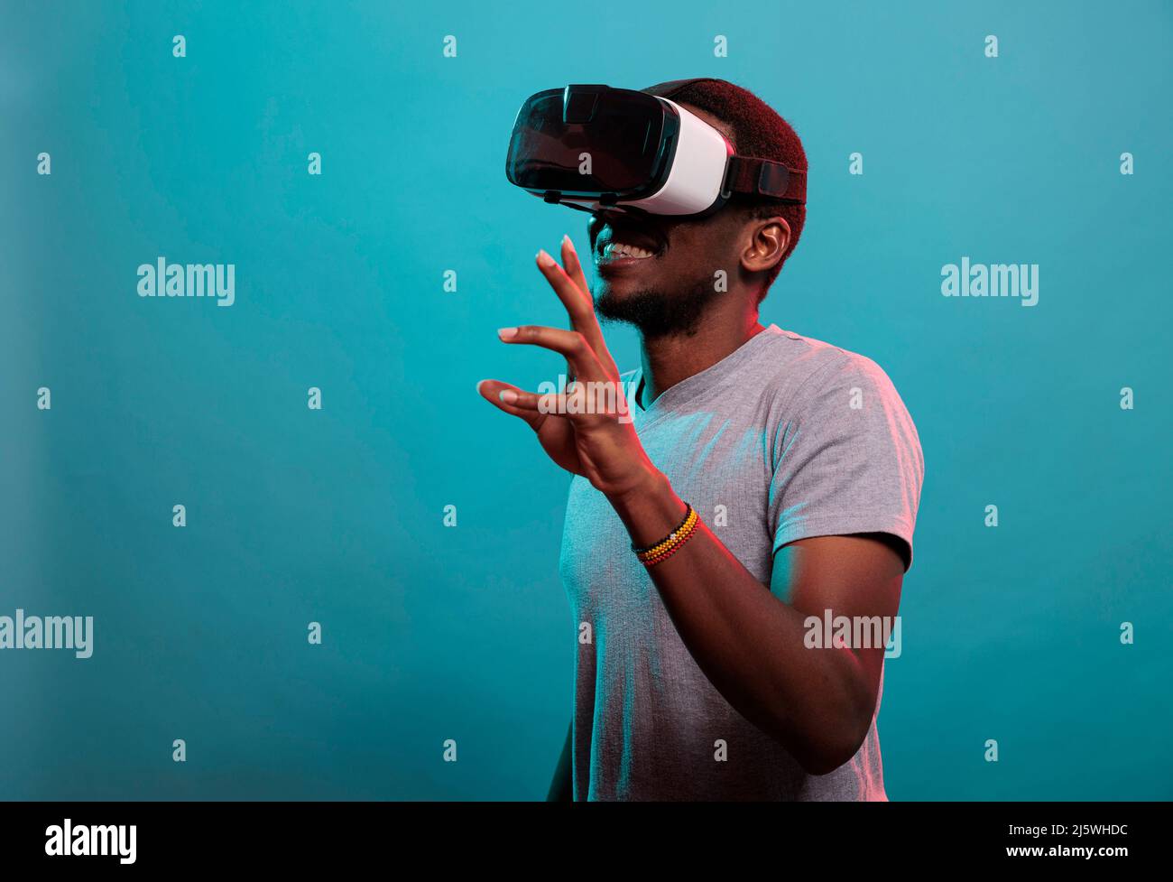 Young man having fun with interactive virtual reality headset, using modern technology with ...