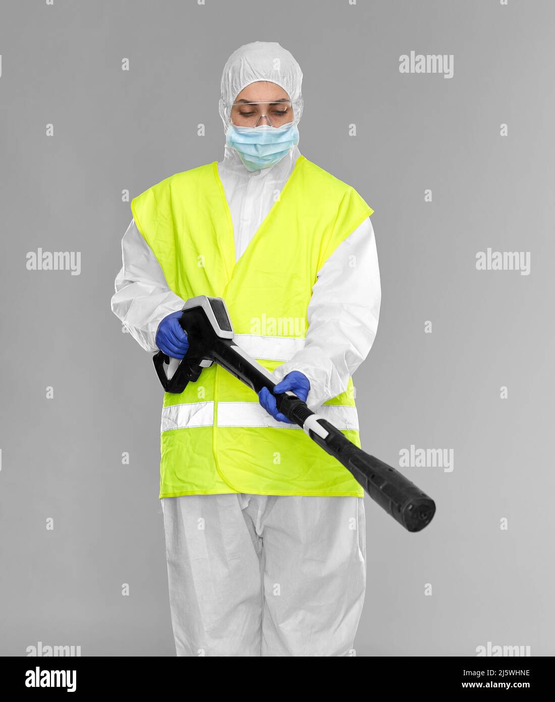 sanitation worker in hazmat with pressure washer Stock Photo - Alamy