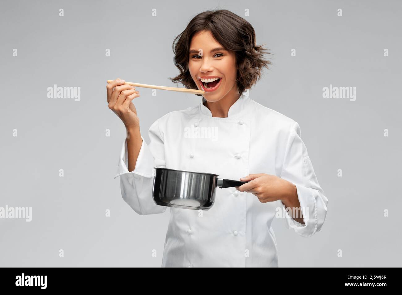 happy female chef with saucepan tasting food Stock Photo - Alamy