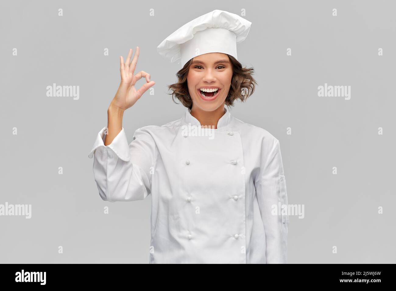 happy smiling female chef showing ok hand sign Stock Photo - Alamy