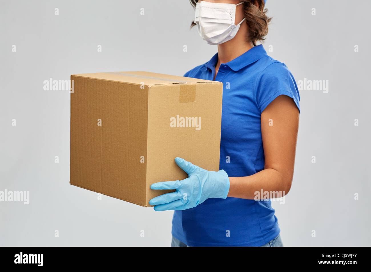 delivery woman in face mask holding parcel box Stock Photo - Alamy