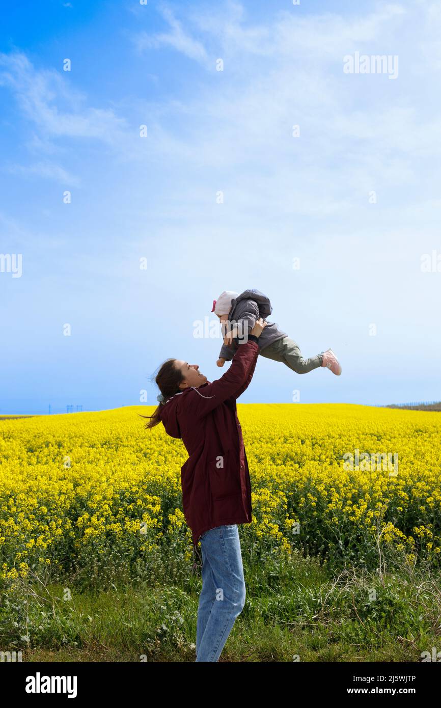 A woman holding her baby in a field on a beautiful sunny day Stock ...
