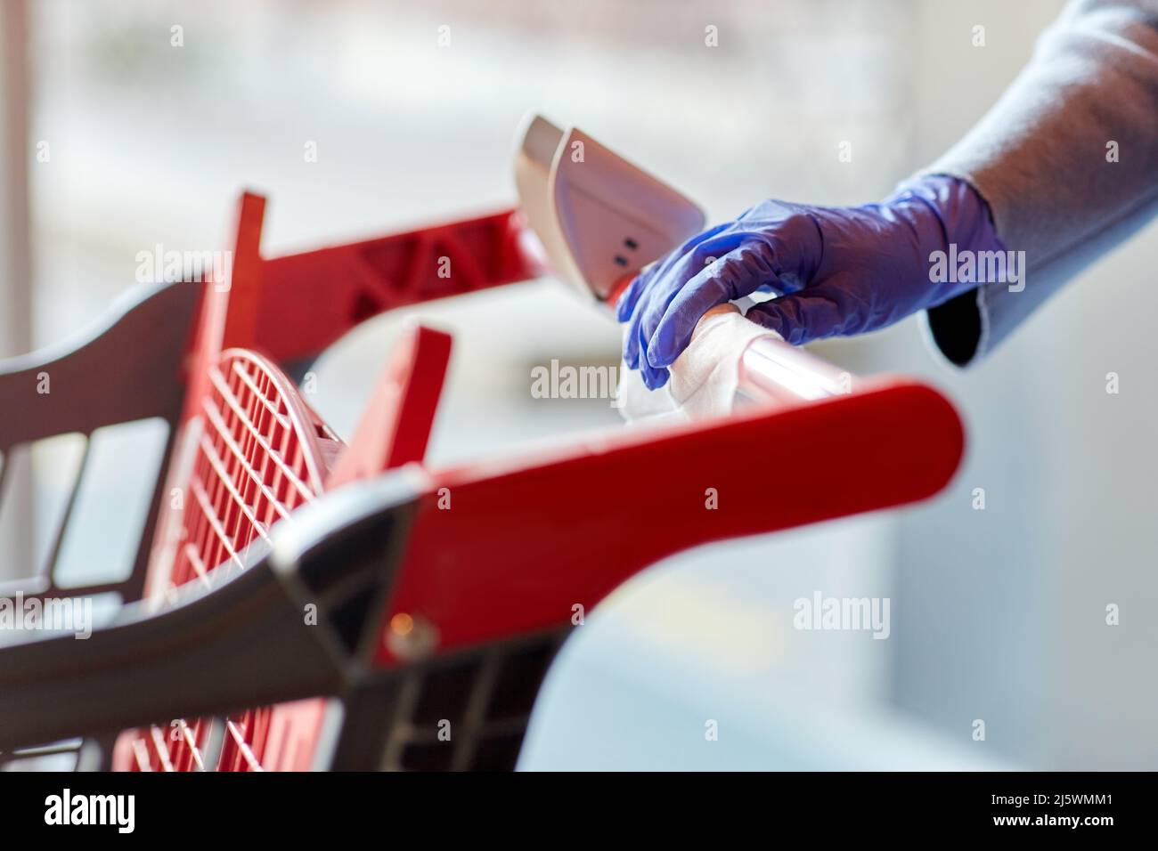 hand cleaning shopping cart handle with wet wipe Stock Photo - Alamy