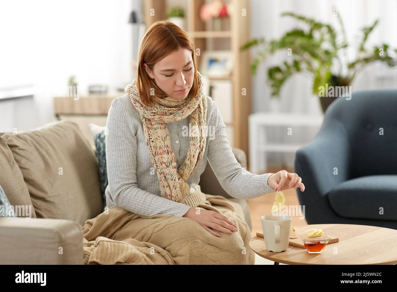 sad sick young woman drinking lemon tea at home Stock Photo - Alamy