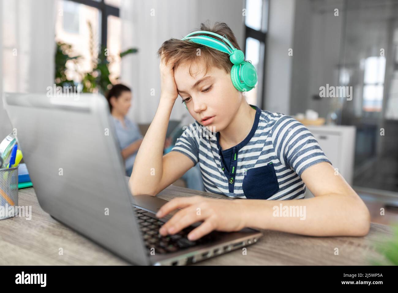sad boy with laptop and headphones at home Stock Photo - Alamy
