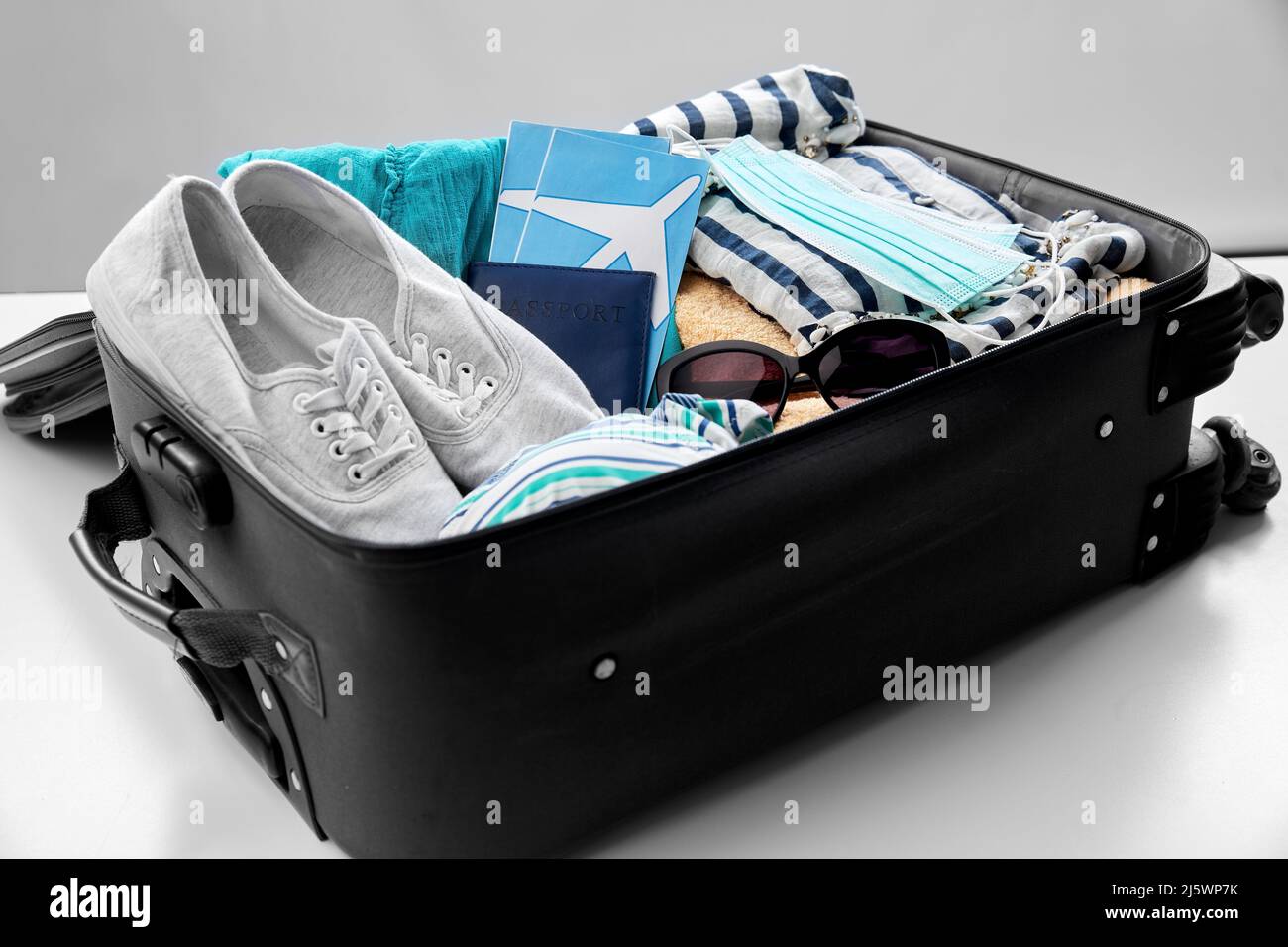 travel bag packed with clothes, tickets and masks Stock Photo - Alamy