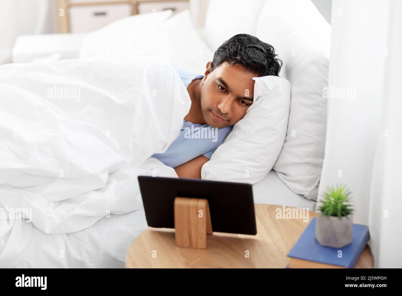 happy indian man with tablet pc in bed at home Stock Photo - Alamy
