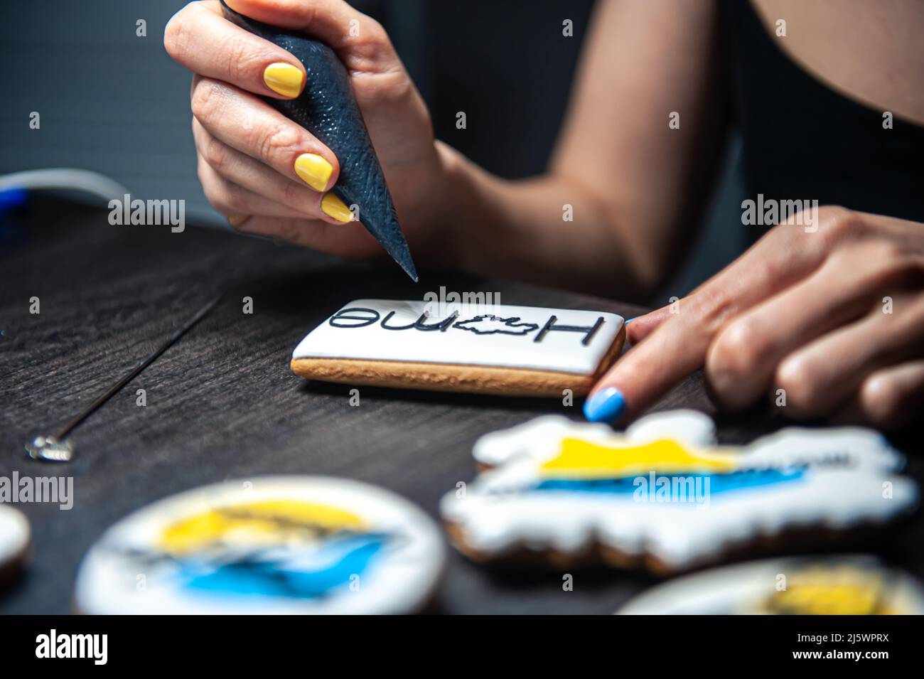 A woman makes patriotic gingerbread in support of Ukraine Stock Photo ...