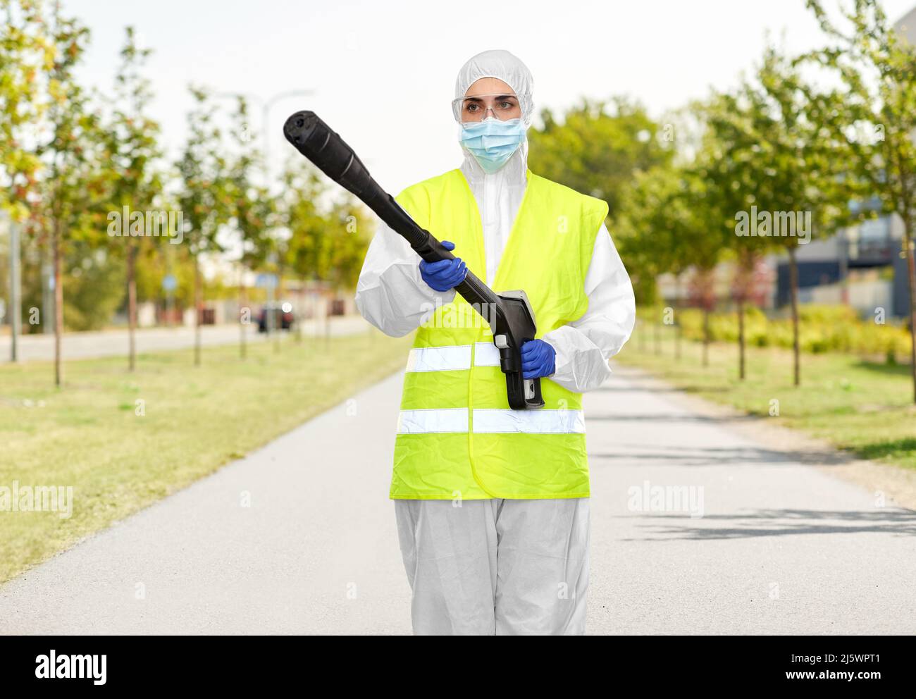 sanitation worker in hazmat with pressure washer Stock Photo - Alamy