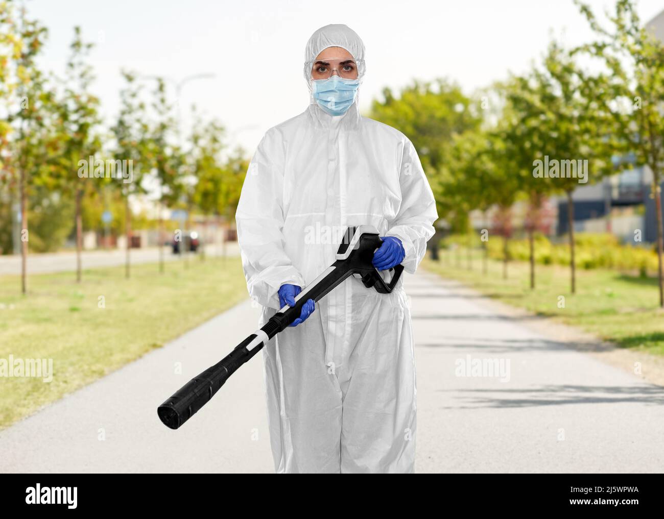sanitation worker in hazmat with pressure washer Stock Photo - Alamy