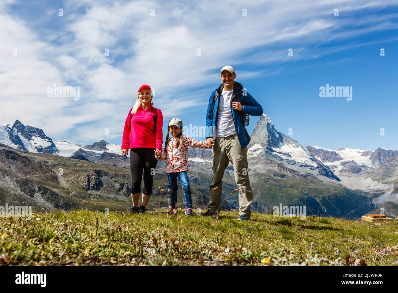 Happy family with little child doing trekking on switzerland mountain ...