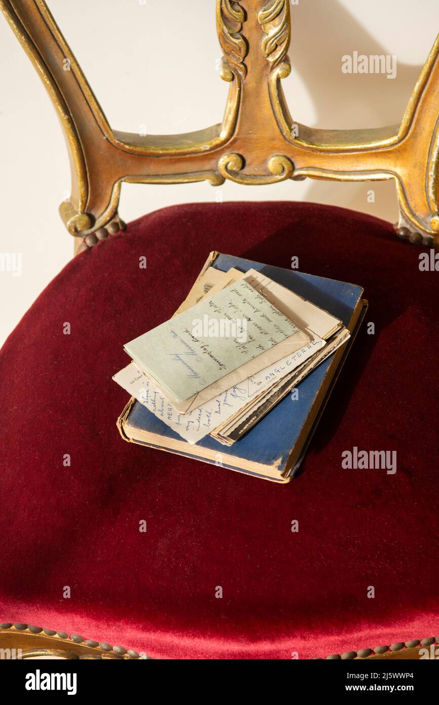 Book and old letters over a red chair Stock Photo - Alamy