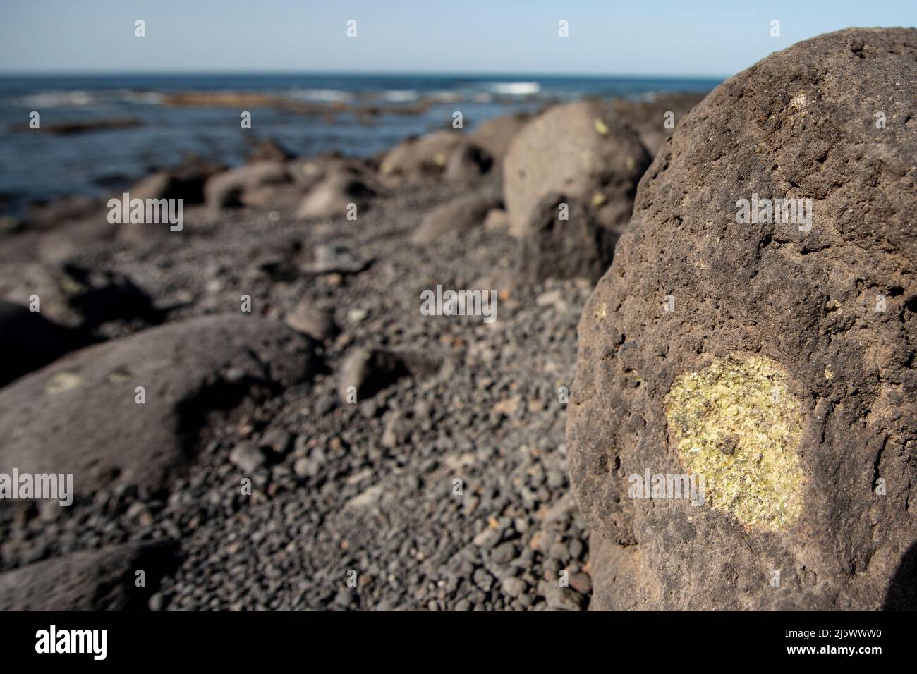 Natural olivine in a lava formed rock on the beach of Lanzarote Stock ...