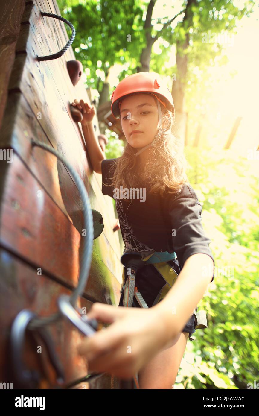 Young girl on the rope park in the forest wearing a helmet Stock Photo ...