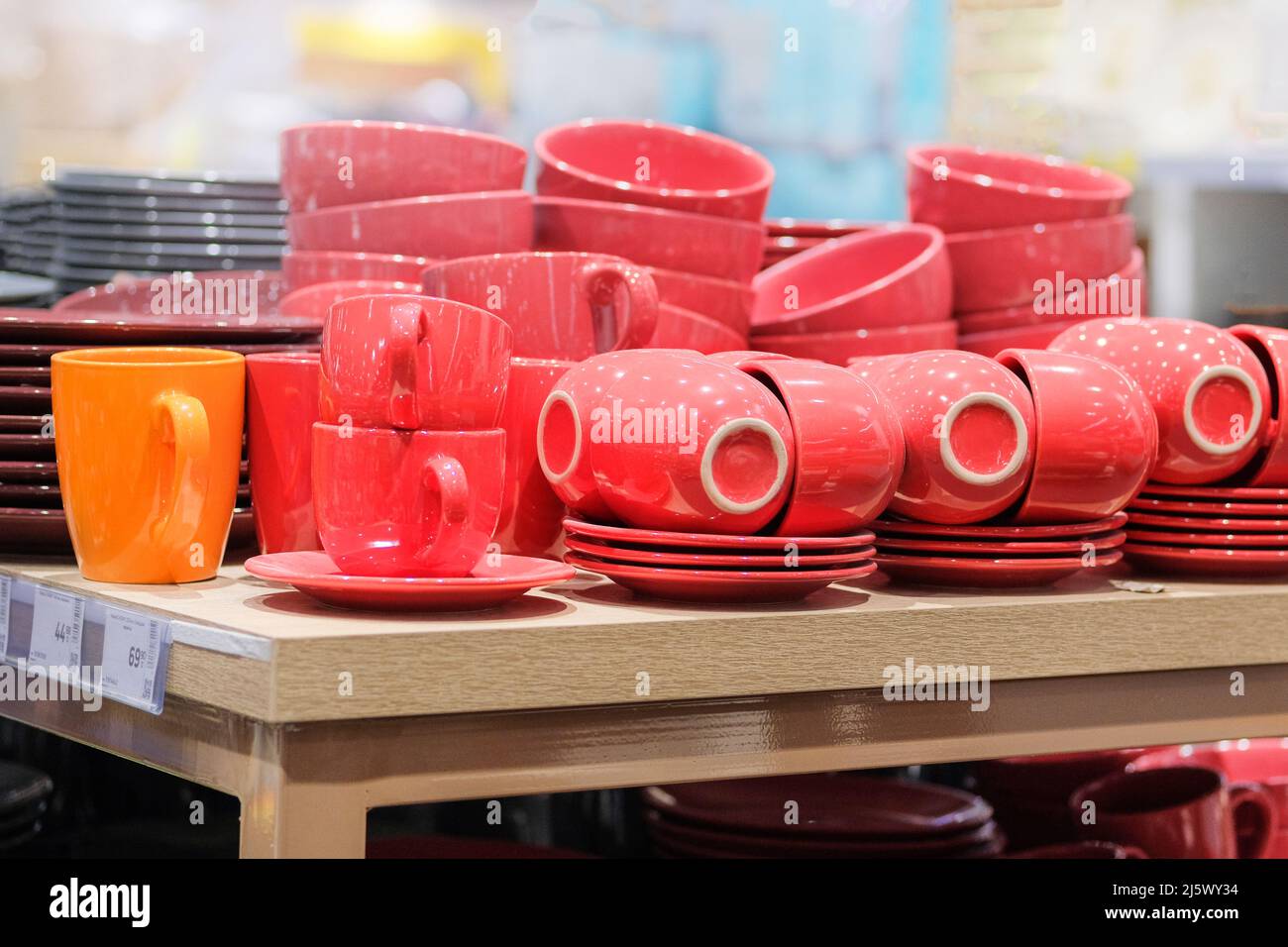 Сups are sold at the store. Rows of different red cups for home on ...