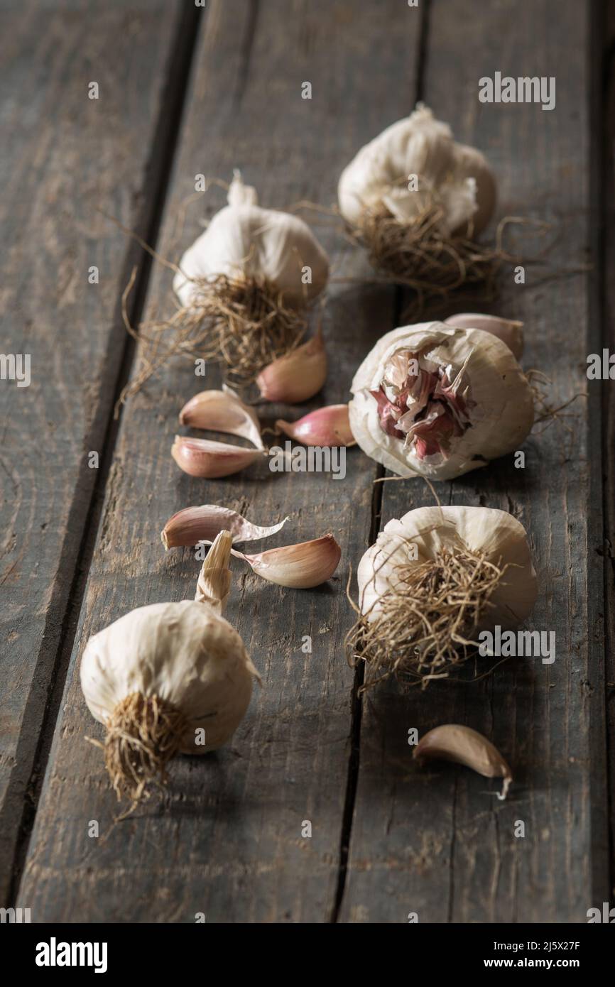 A scattering of garlic on a wooden texture. Concept: food, vegetables ...