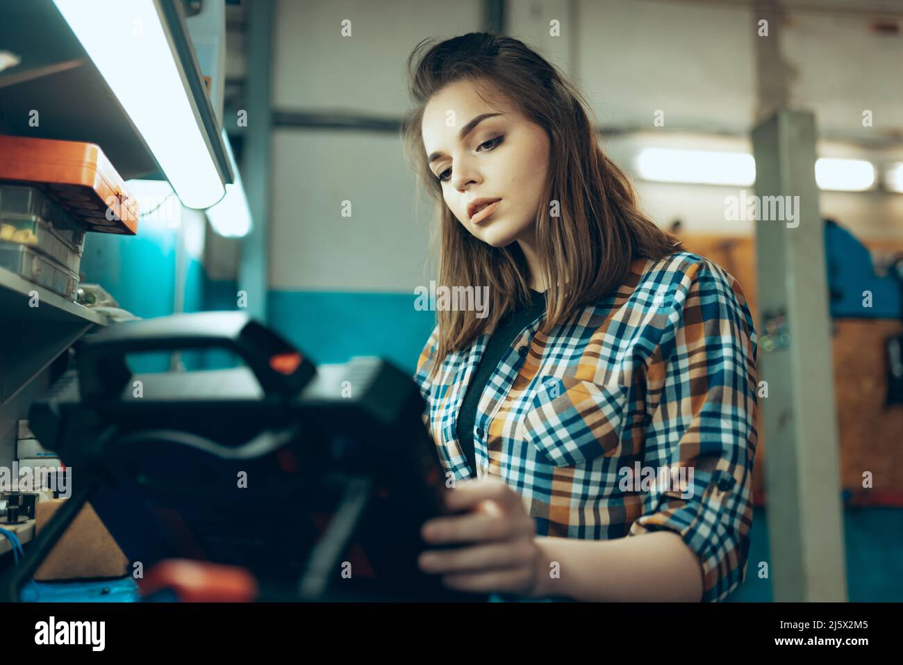 Female auto mechanic, beautiful young girl in working process at auto ...