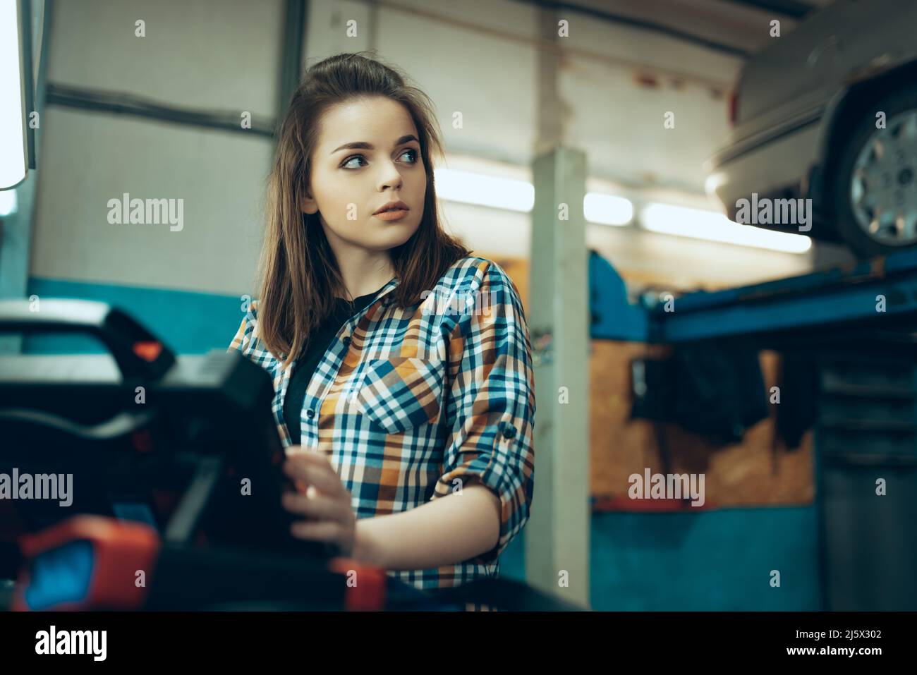 Female auto mechanic at auto service station, indoors. Gender equality ...