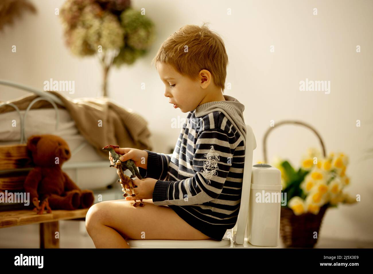 Cute toddler child, boy, using potty at home, while playing with toys ...