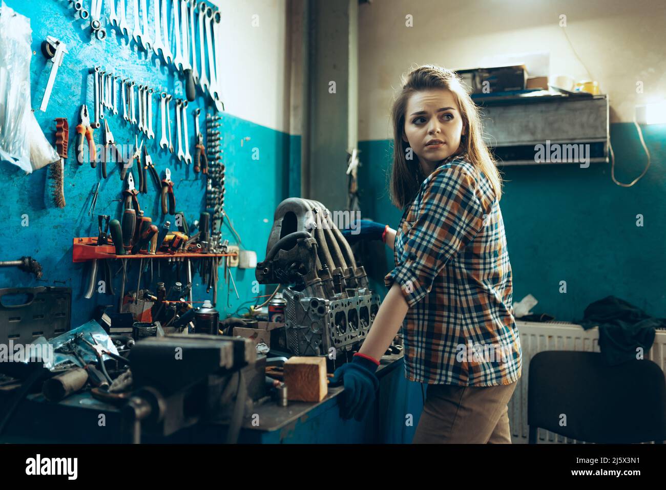 Female auto mechanic, beautiful young girl in working process at auto ...