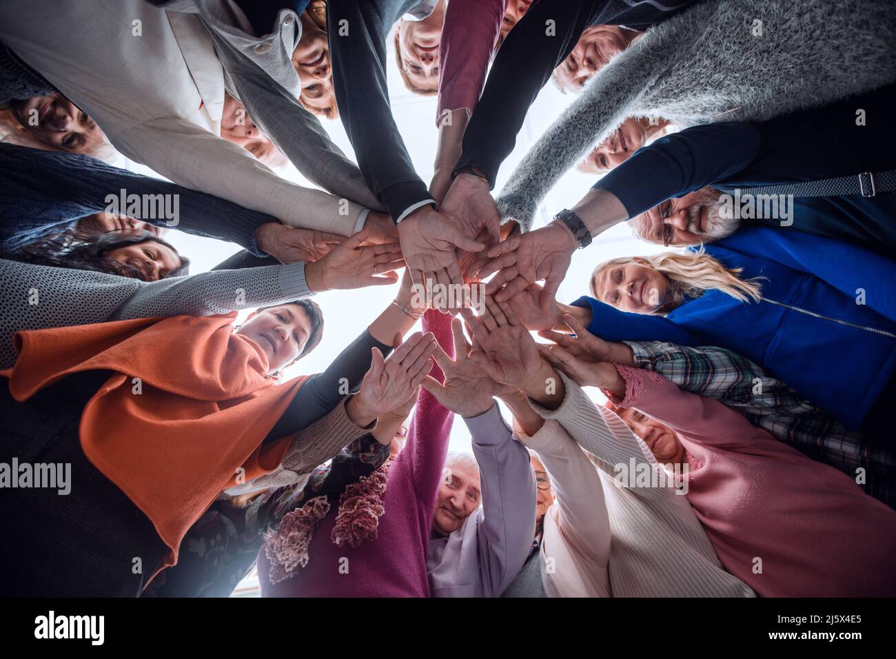 Creative business team stacking hands together in office Stock Photo ...