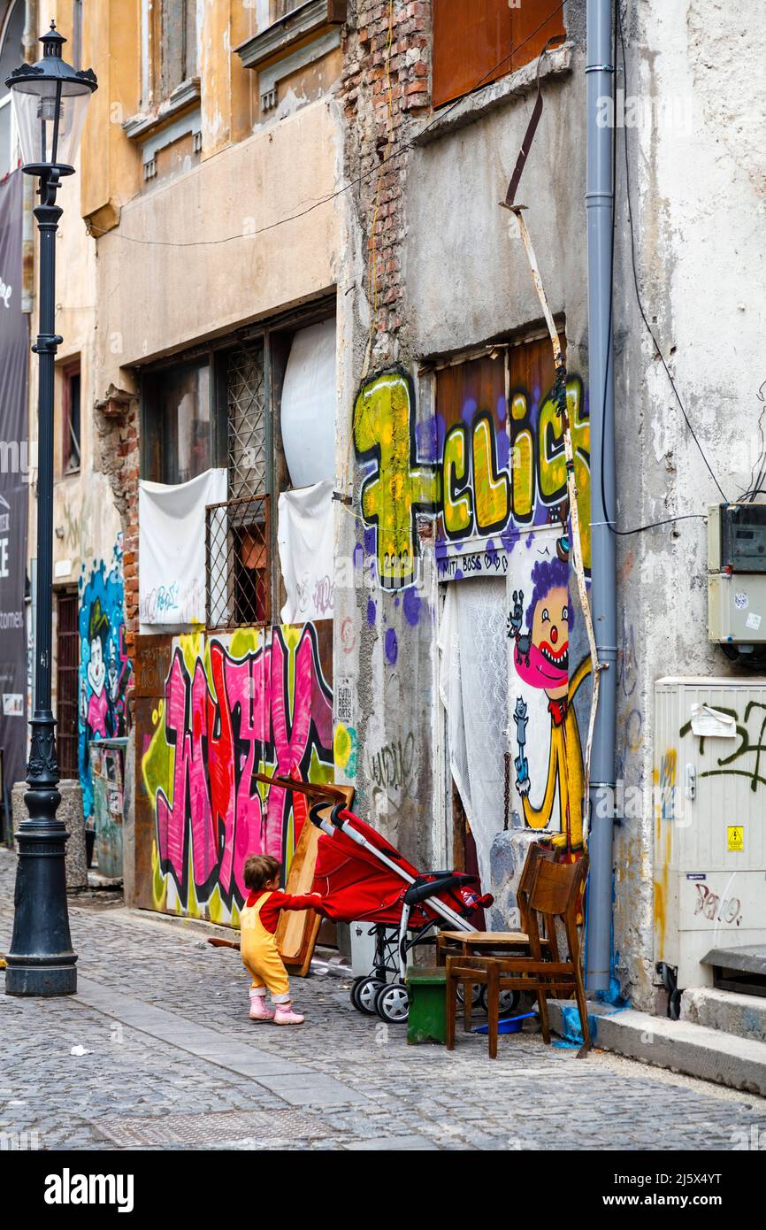 Run down side street with graffiti on walls of crumbling buildings in ...