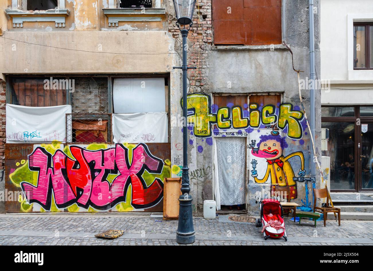 Run down side street with graffiti on walls of crumbling buildings in ...