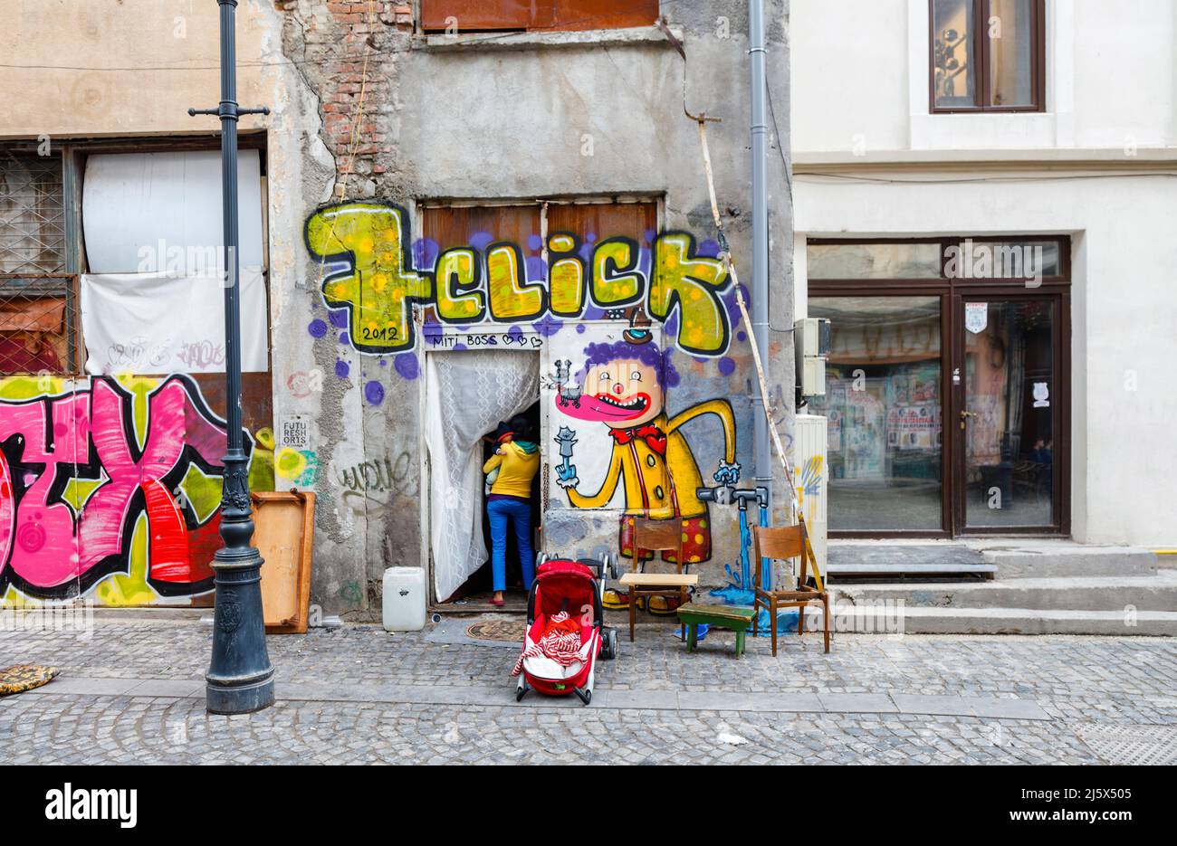 Run down side street with graffiti on walls of crumbling buildings in ...