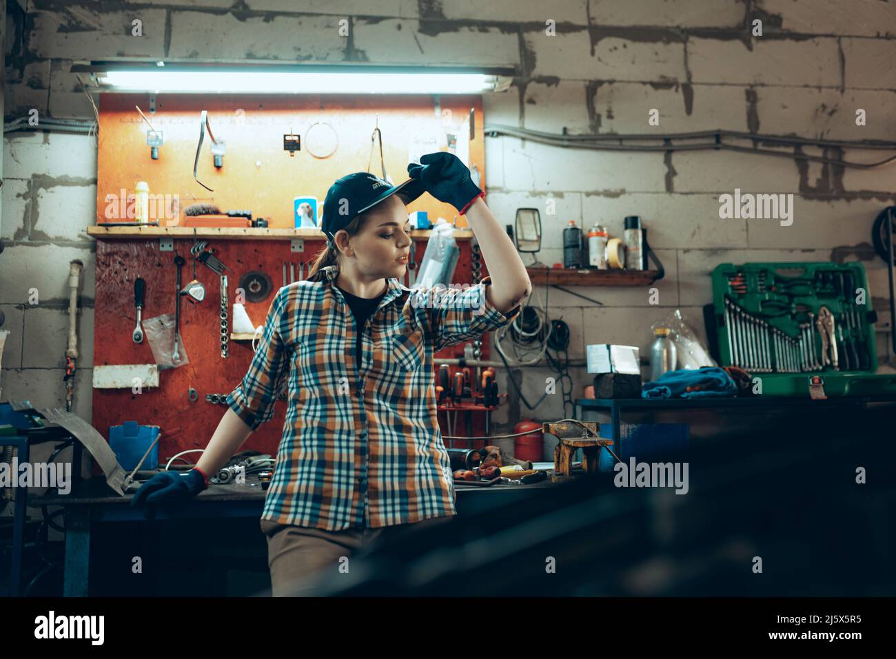 Female auto mechanic, beautiful young girl in working process at auto ...
