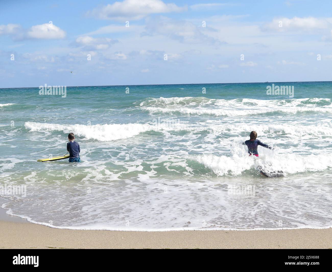Kids playing in the surf with boogie boards at west Palm Beach, Florida ...