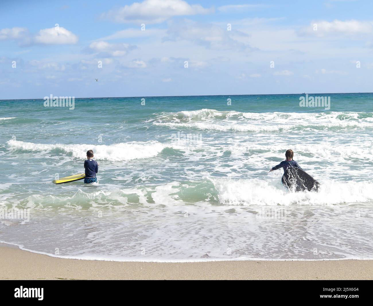 Kids playing in the surf with boogie boards at west Palm Beach, Florida ...