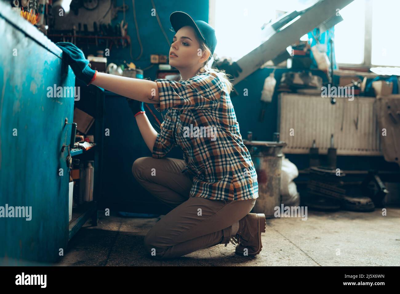 Female auto mechanic at auto service station, indoors. Gender equality ...