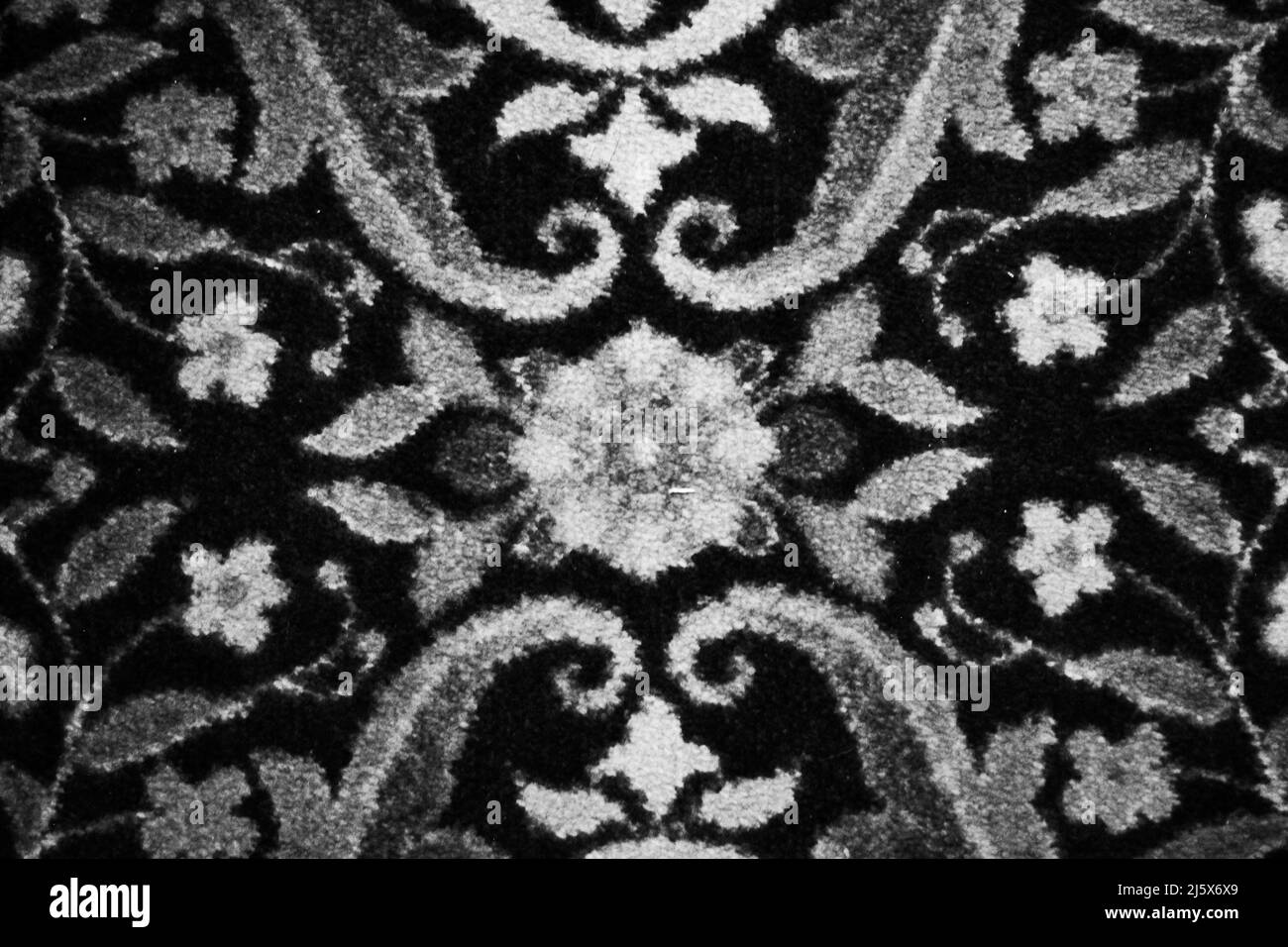 A vintage carpet with a floral motif with plants, flowers, and leaves ...