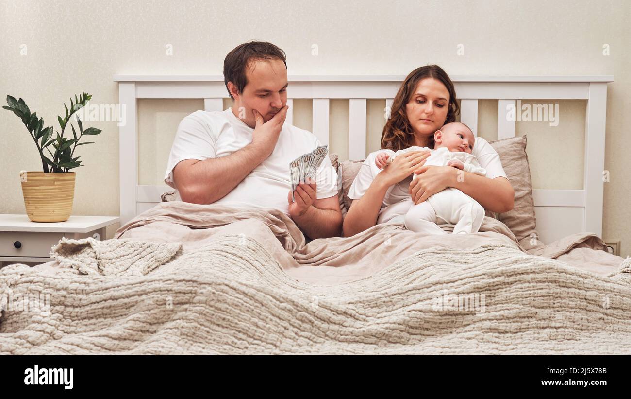 Mother and father with baby boy with money for upbringing, financial ...