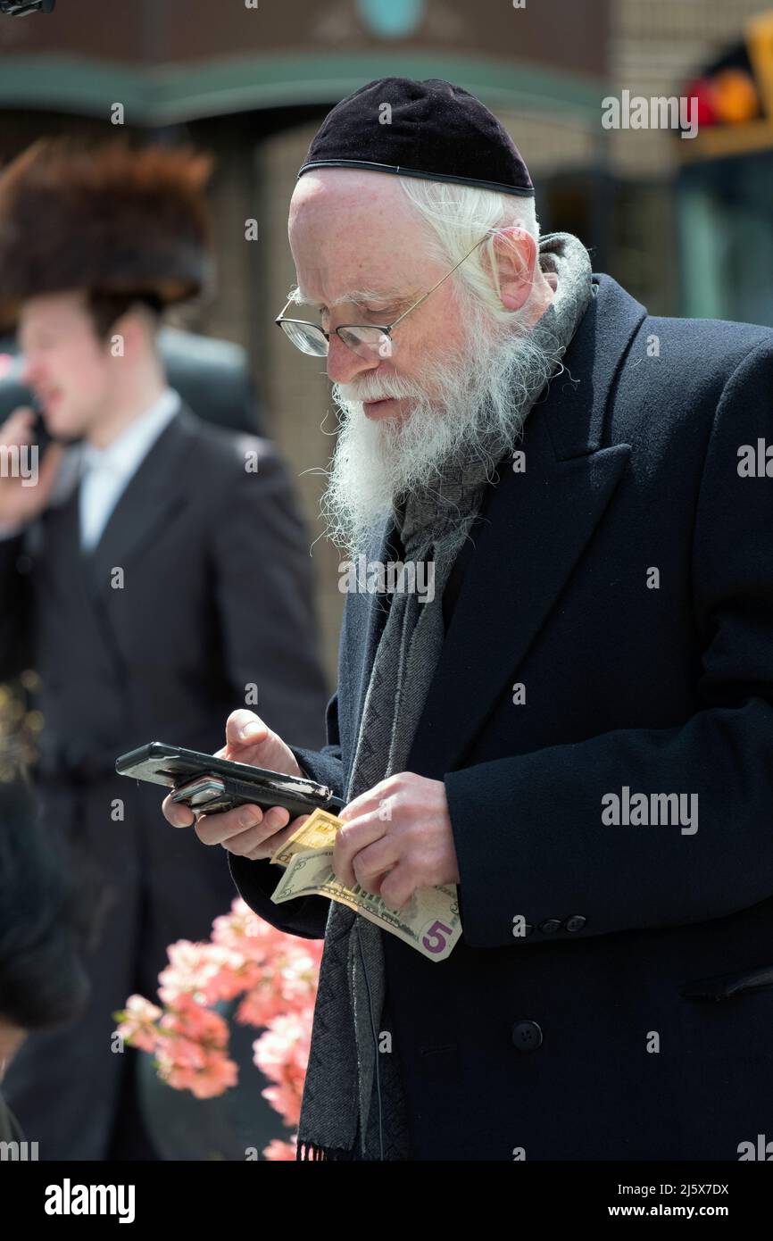 On Passover, an orthodox Jewish man checks his flip phone while ...