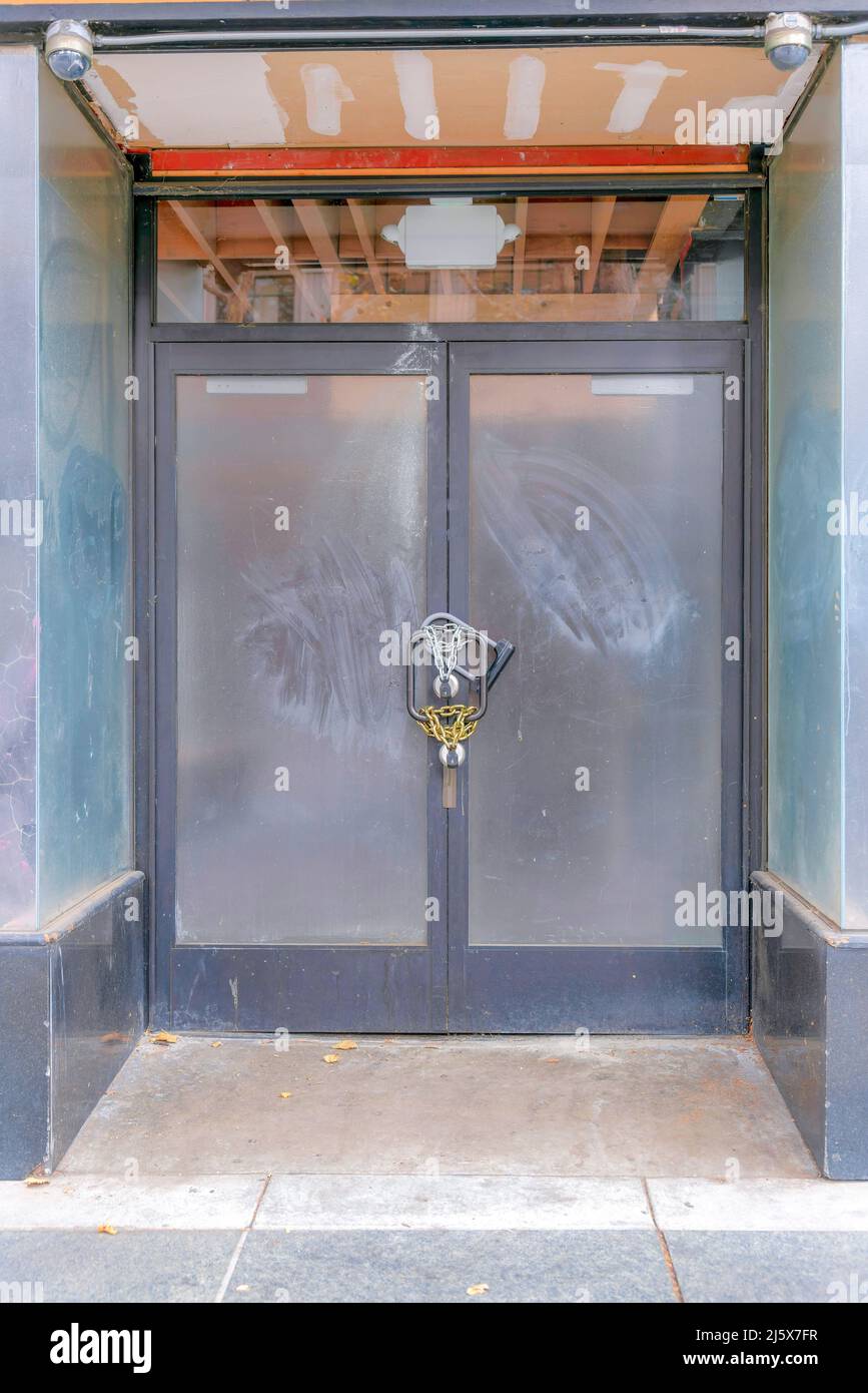 Unfinished building with double doors with glass and padlocks at ...
