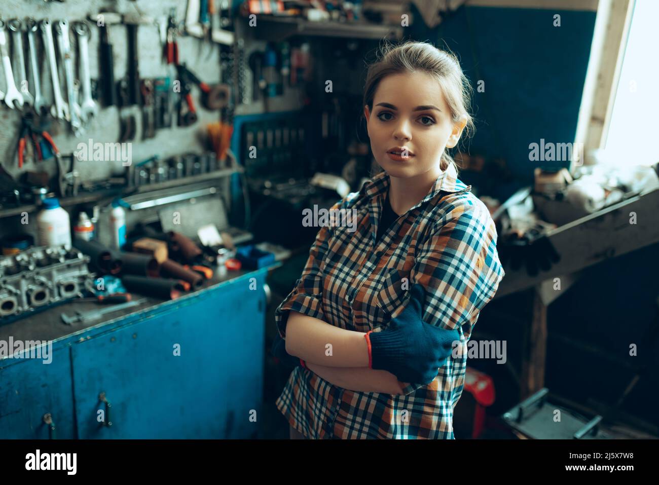 Portrait of young confident girl wearing working clothes standing at ...