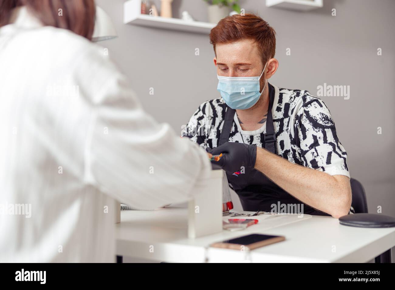 Nail master working on client nails at beauty center Stock Photo - Alamy