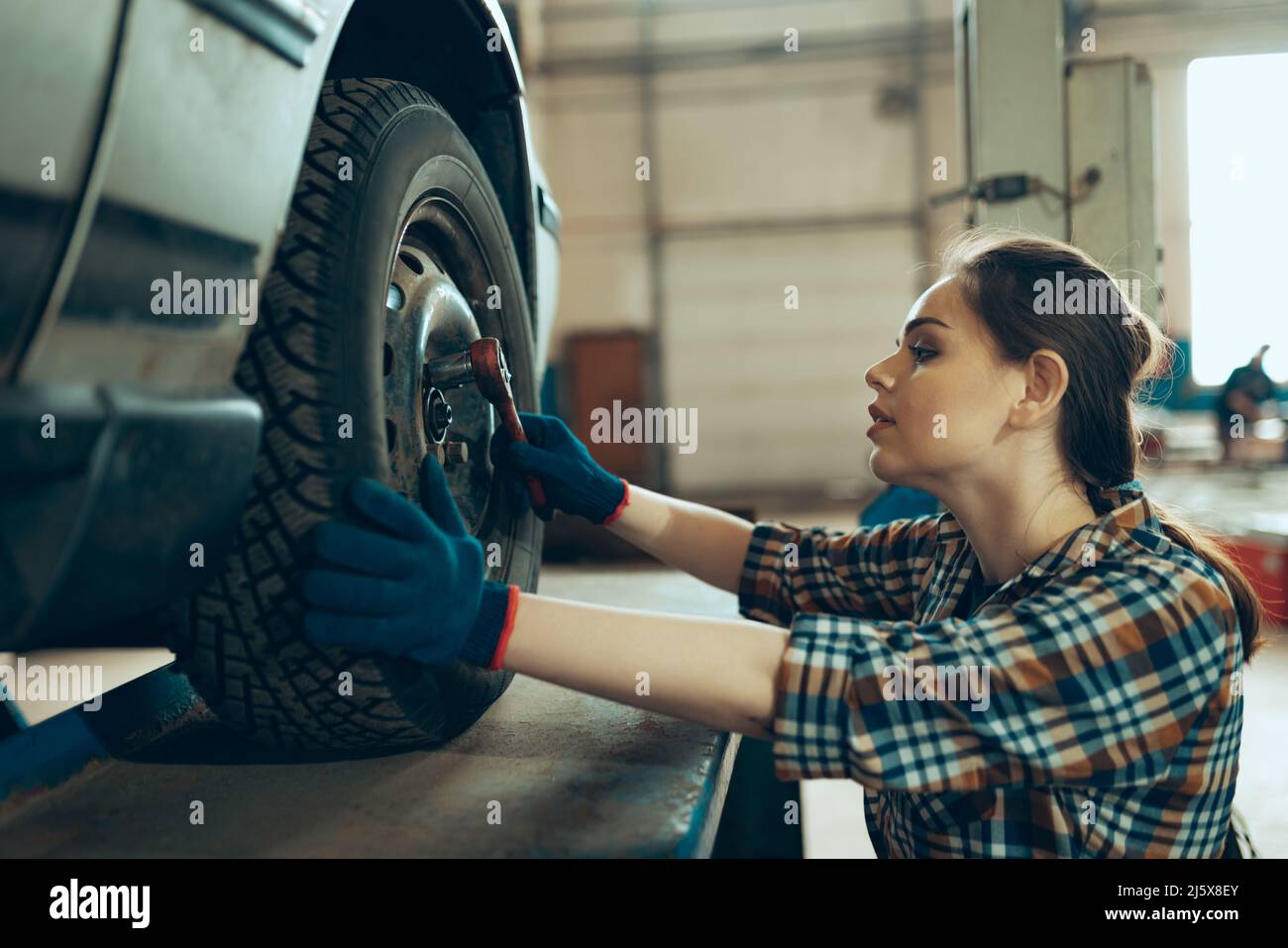 Female auto mechanic, beautiful young girl in working process at auto ...