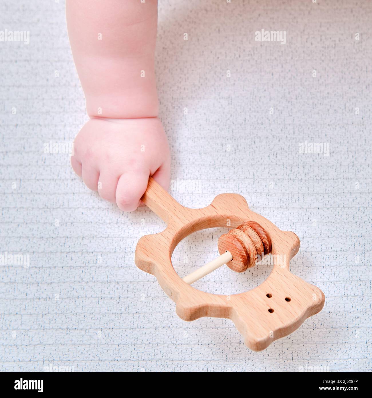 Baby hand and toy rattle abacus, close-up. Children fingers and an ...