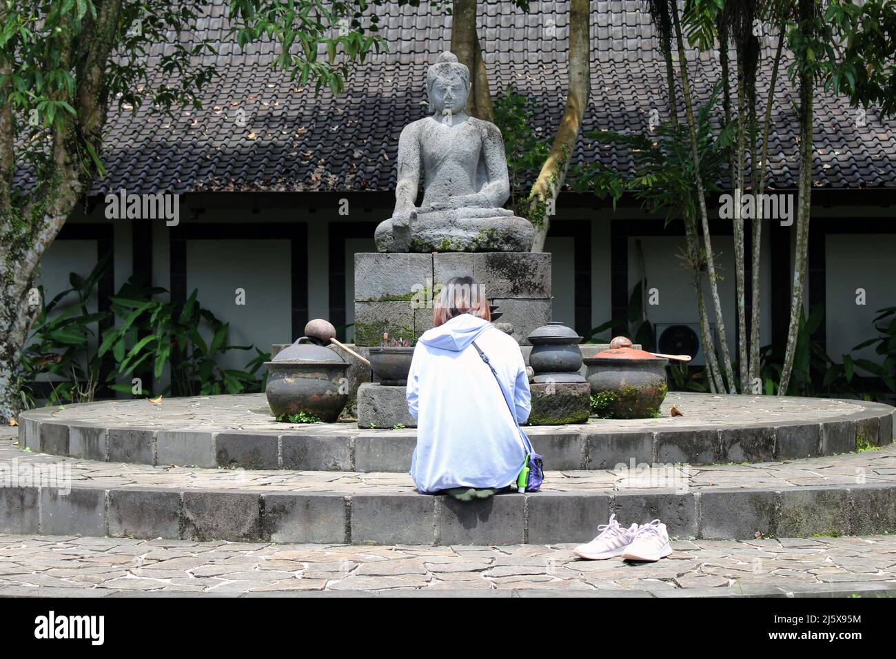 A girl praying at main buddha statue at Borobudur temple. Taken March ...