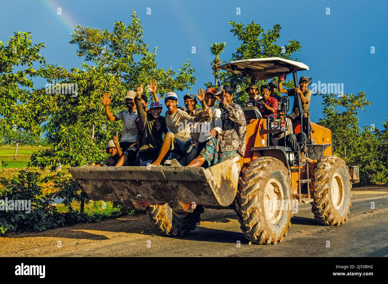 tractor overloaded w/ Khmers smiing & waving Rainbow in background ...