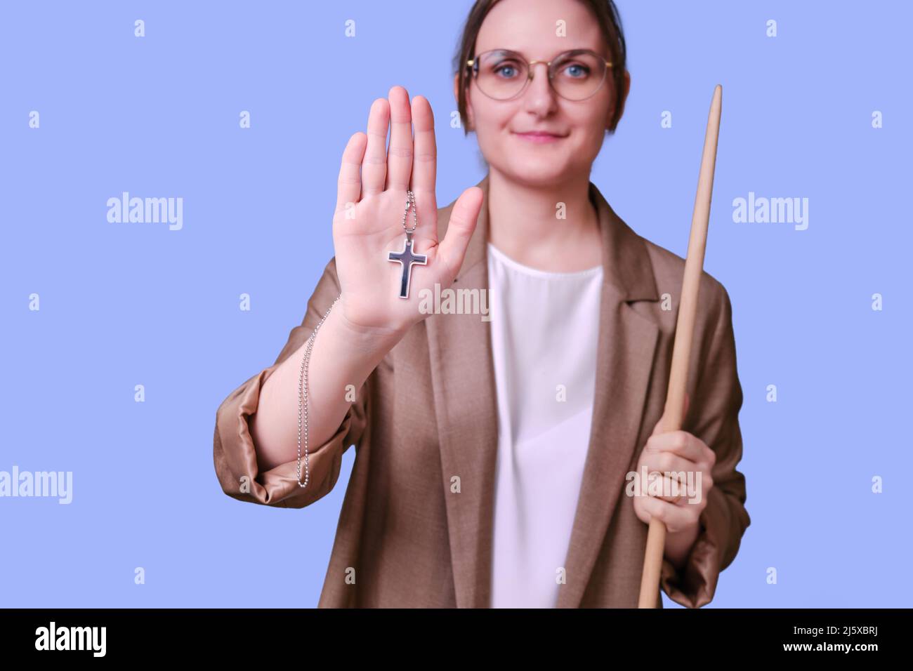 Happy woman teacher with christian religious symbol cross on blue ...
