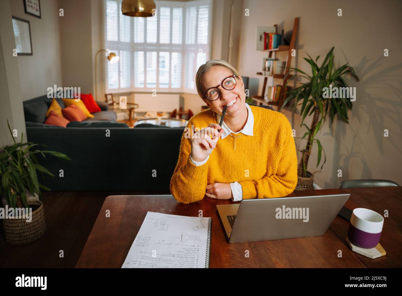 Caucasian female woman working from home smiling while thinking into ...