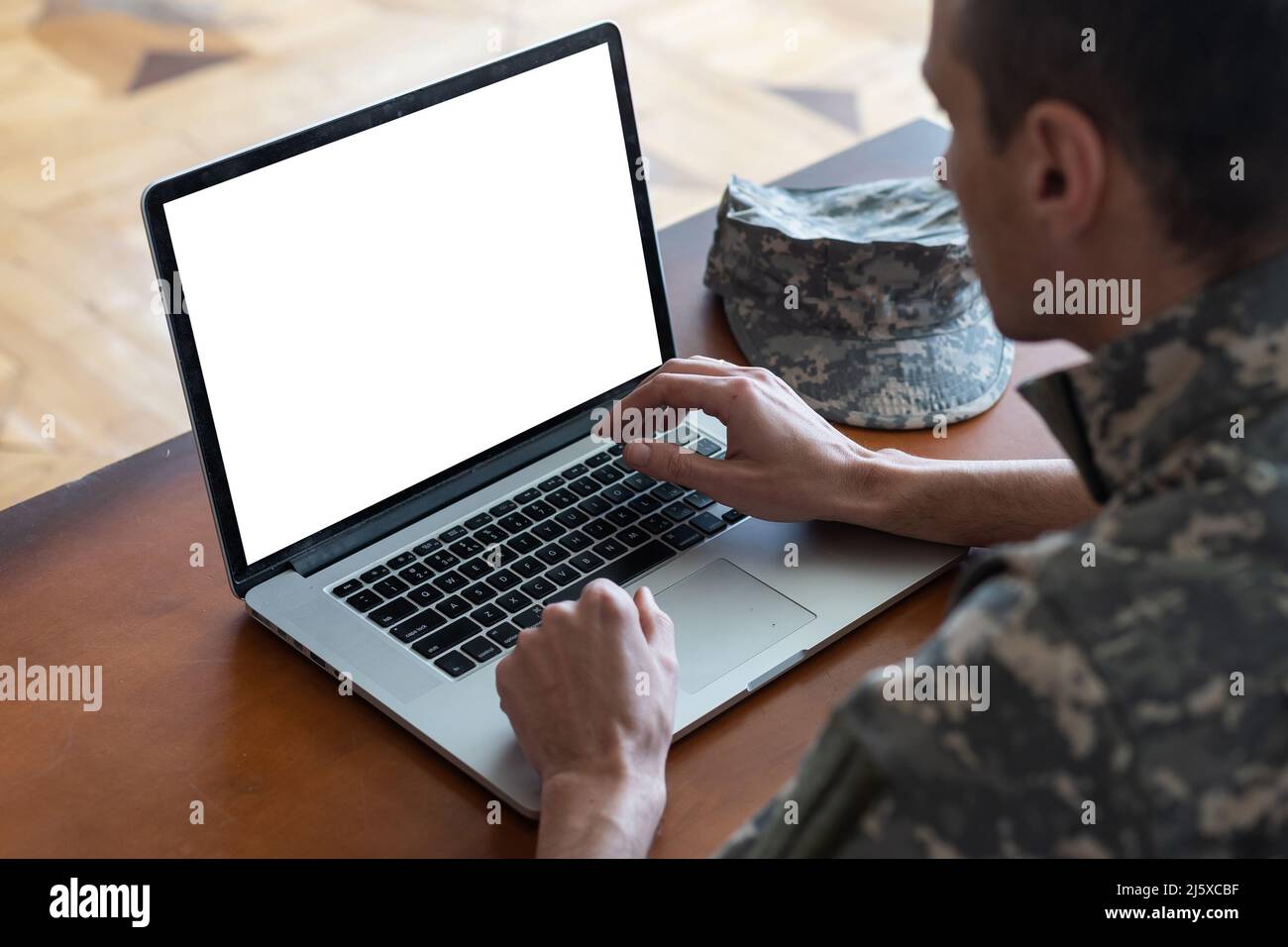 Army. Young soldier working with a laptop computer with blank screen on ...