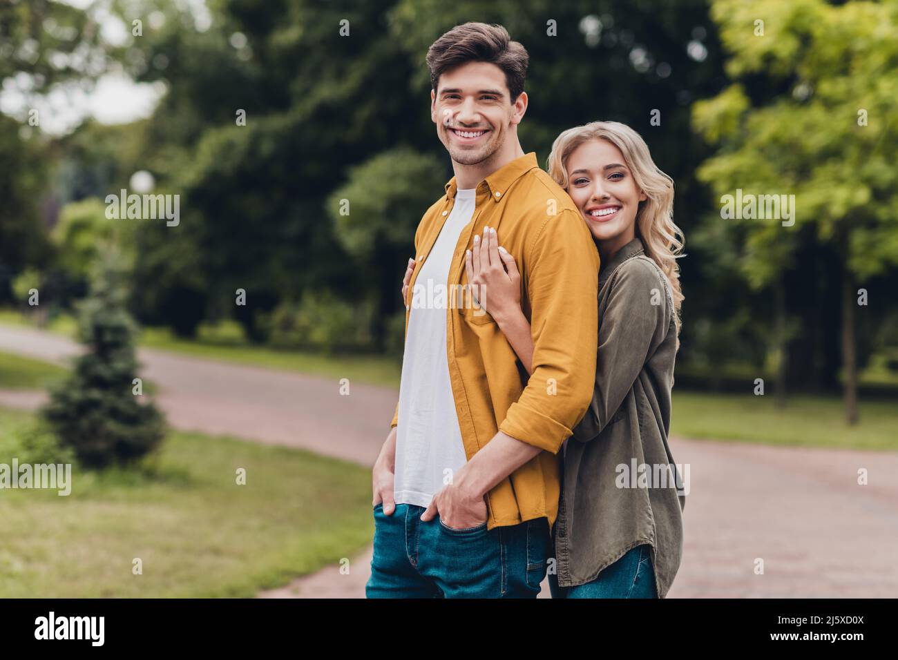 Portrait of attractive cheerful amorous couple spouses hugging cuddling ...