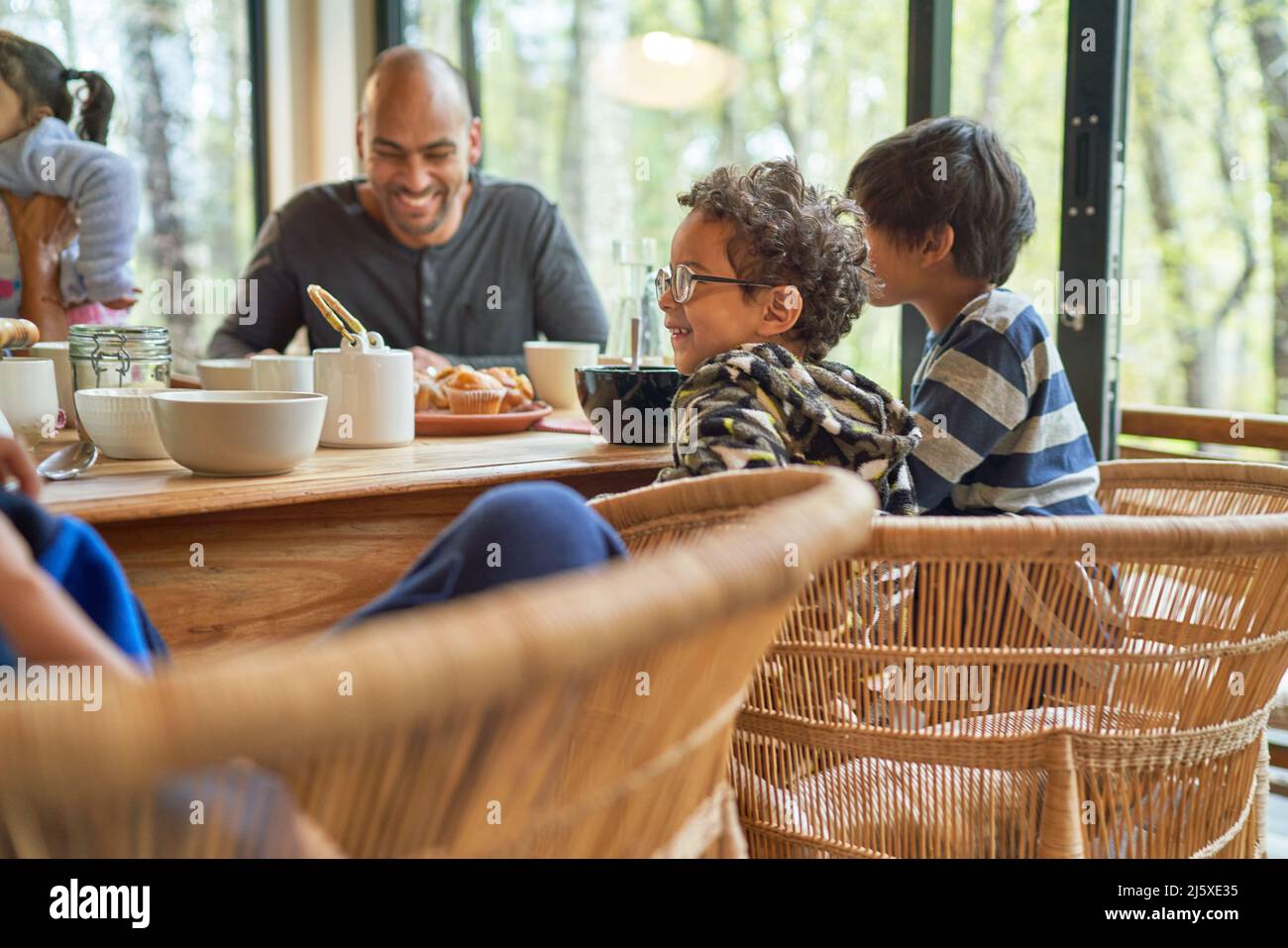 Happy family eating at dining table Stock Photo - Alamy
